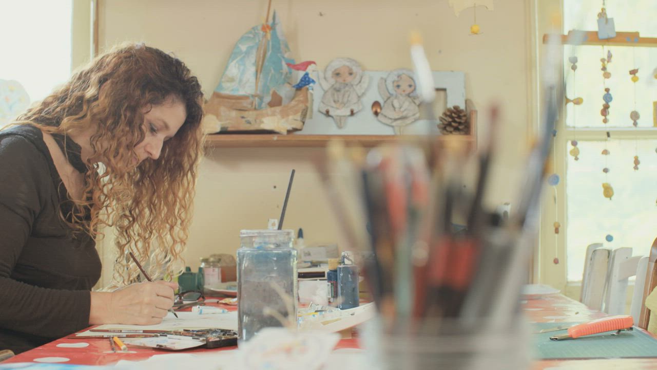 Woman sitting in a studio painting with watercolors - Free Stock Video