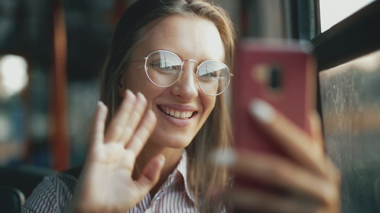 Young woman says hi in a video call - Free Stock Video