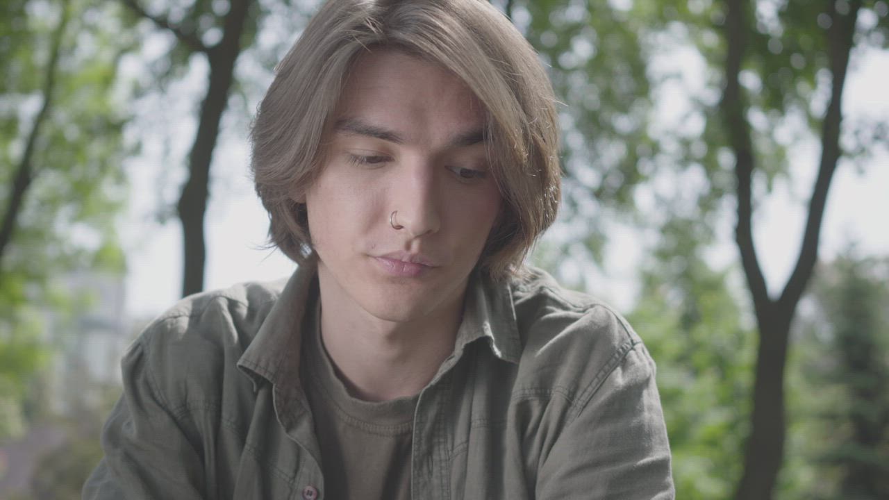 Sad and worried young man in a park - Free Stock Video