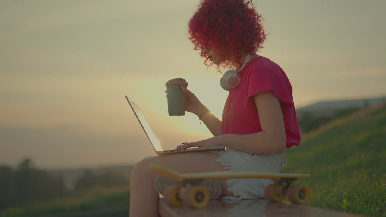 Young woman working outdoors in a beautiful sunset - Free Stock Video