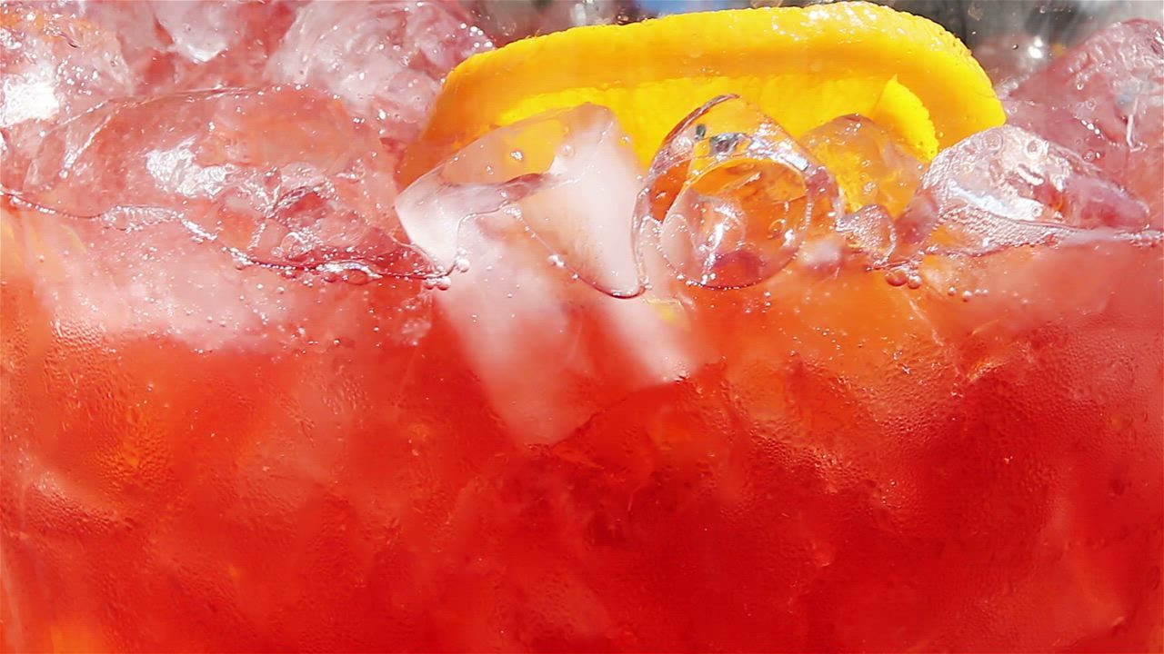 Close up of an ice jug of fruit punch being stirred - Free Stock Video