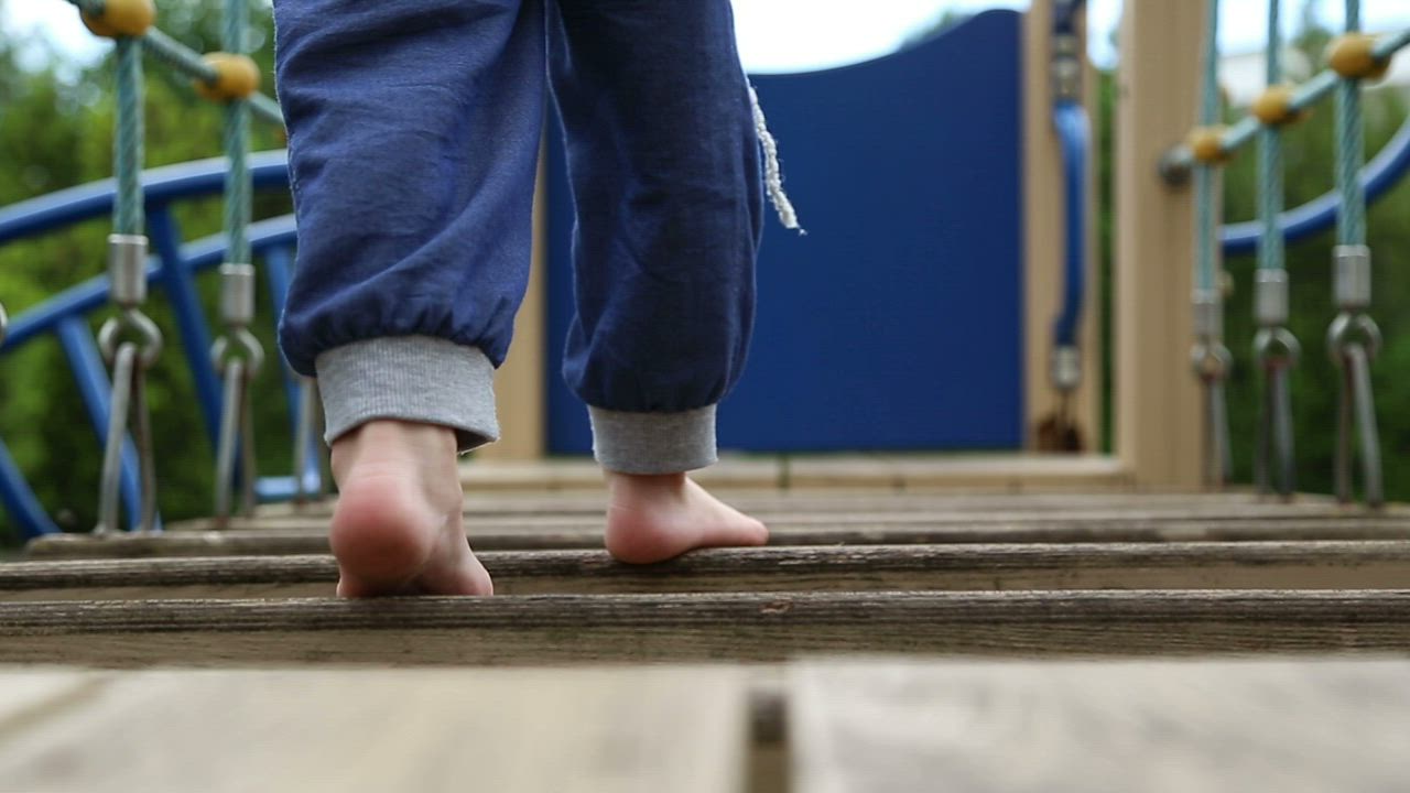 Legs of a child walking barefoot on play bridge - Free Stock Video