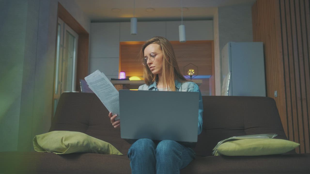 Young woman doing paperwork at home - Free Stock Video