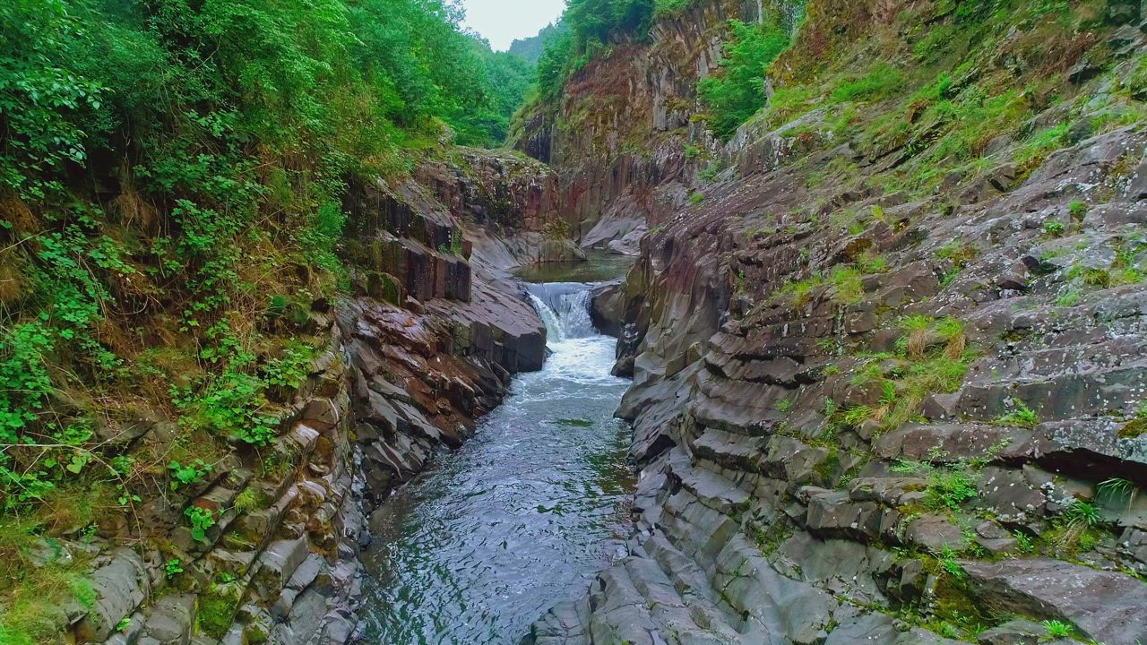 Relaxing waterfall running through rocky cliffs - Free Stock Video