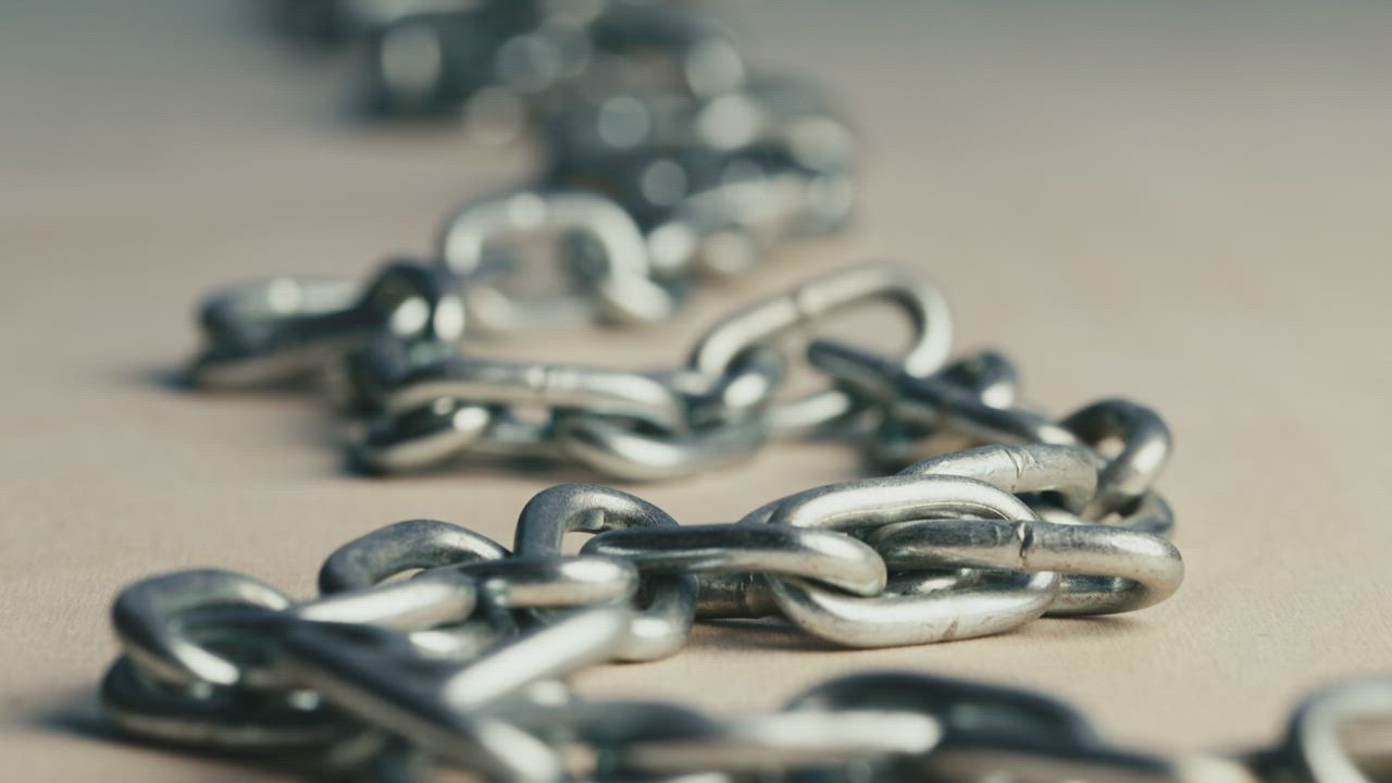 Long metal chain on white surface - Free Stock Video