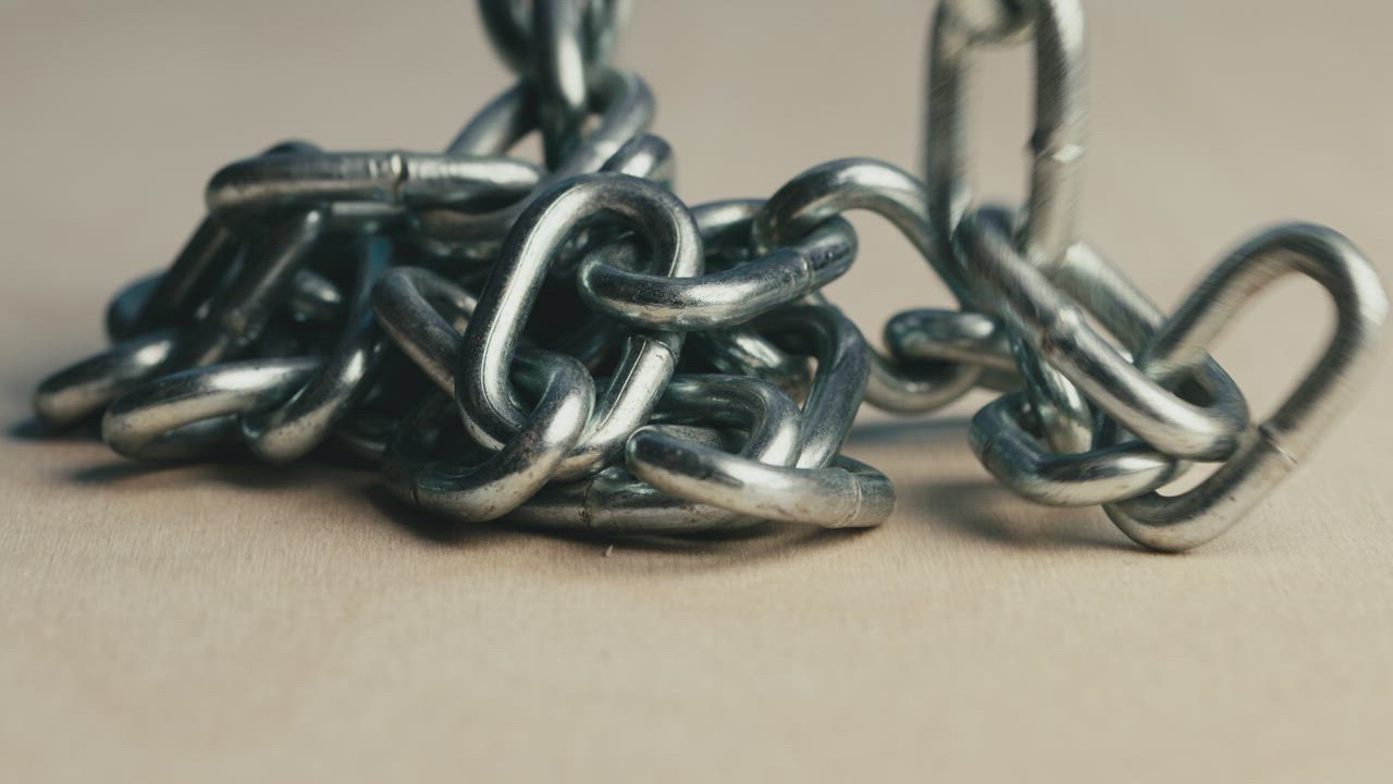 Long metal chain is placed against a white background - Free Stock Video