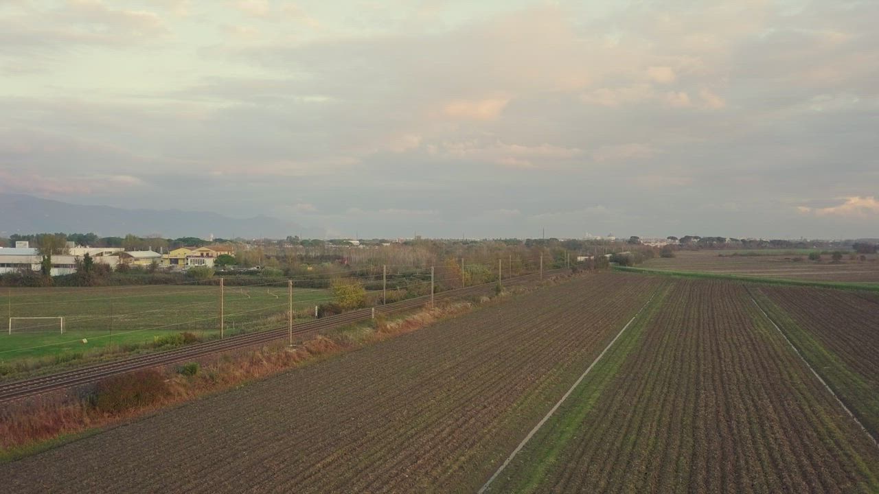 Passenger train passing next to a farm field - Free Stock Video
