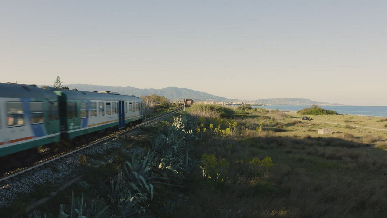 Passenger train passing alongside the sea - Free Stock Video