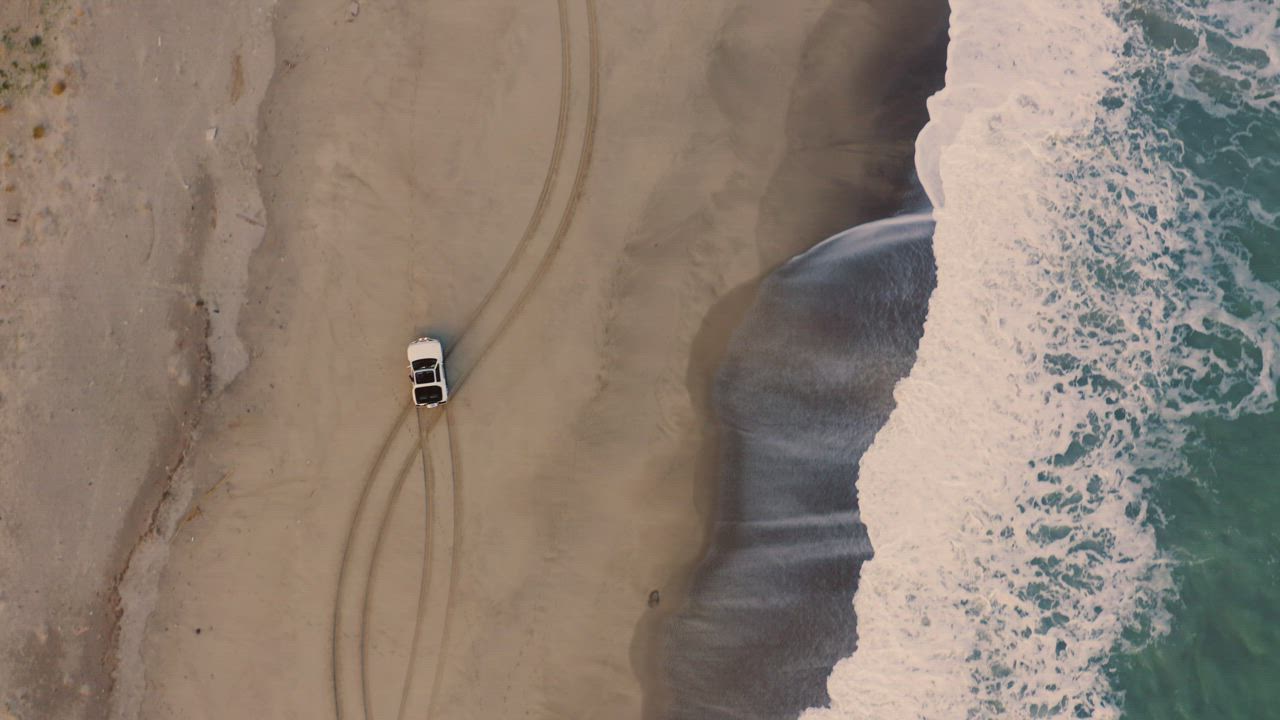 Car driving freely along the seashore at sunset - Free Stock Video