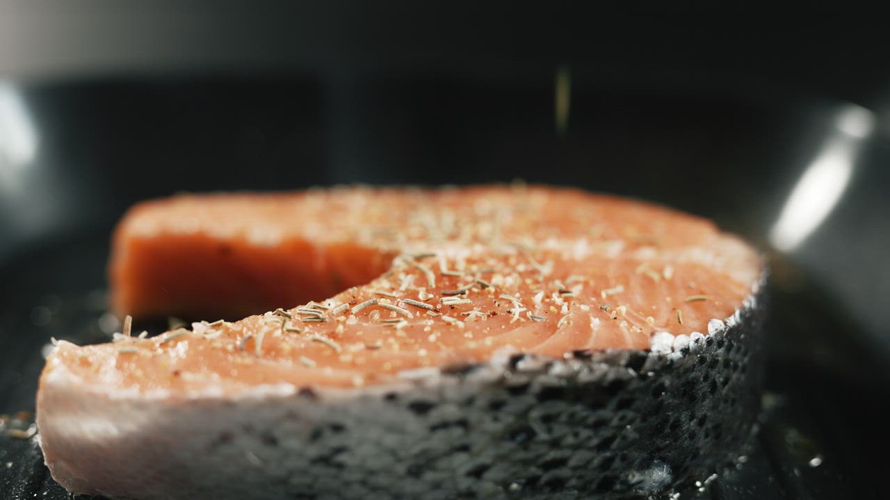 Raw salmon over a heated grill - Free Stock Video