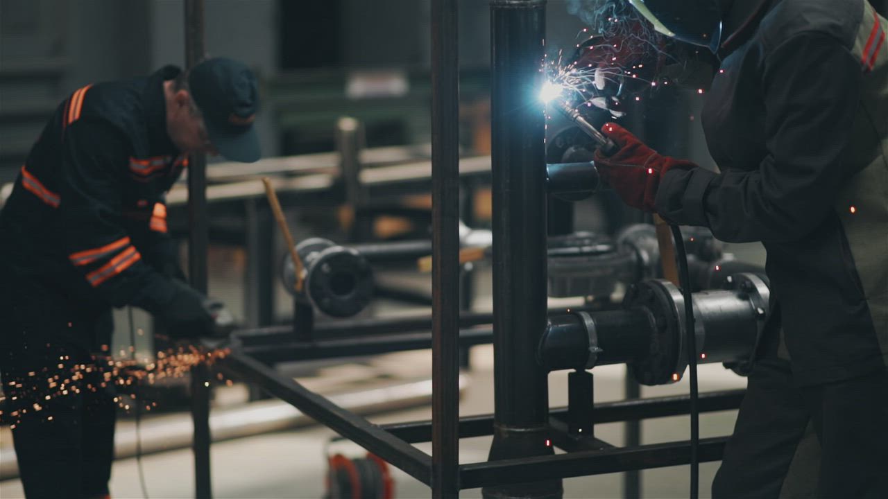 Workers welding heavy metal in a factory - Free Stock Video