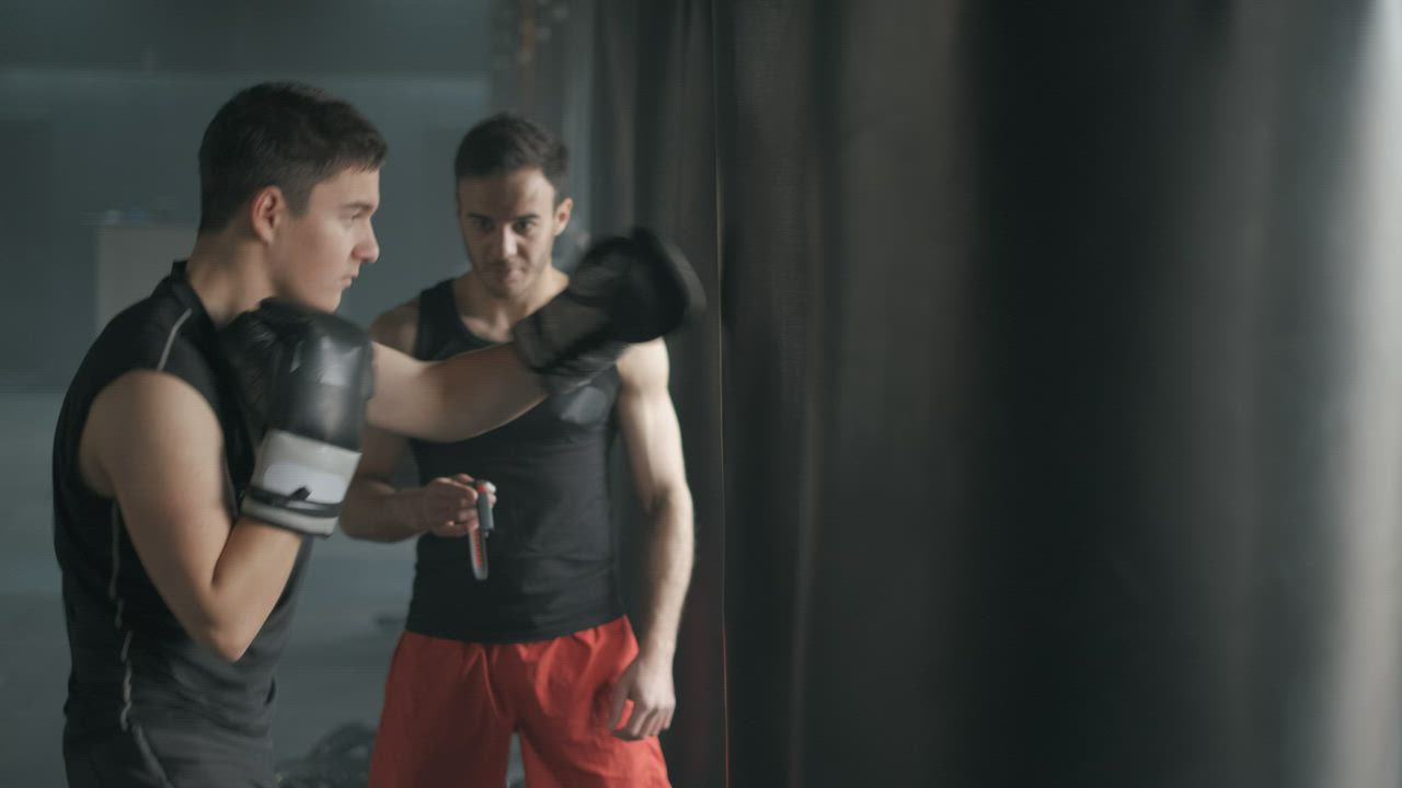 Personal trainer take time in a boxing training - Free Stock Video