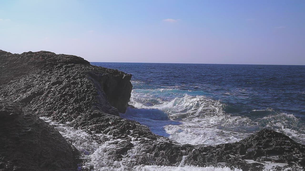 Horizontal view of waves crashing on the rocks - Free Stock Video