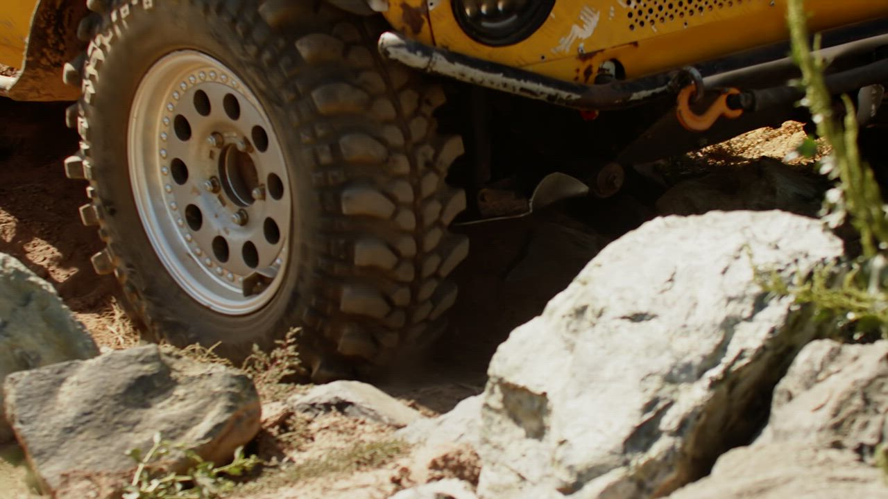 SUV driving over rocks as it goes off road driving - Free Stock Video