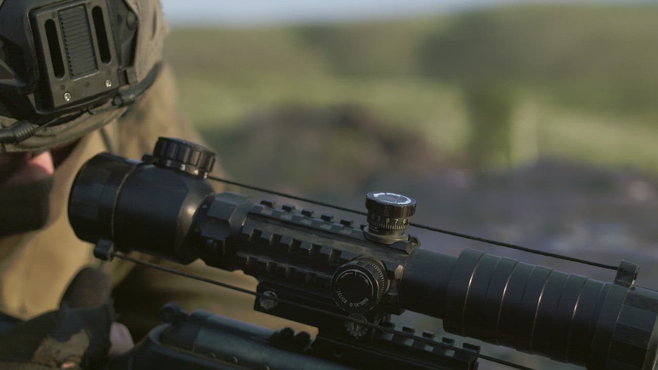 Close up of a sniper checking the scope of a rifle - Free Stock Video