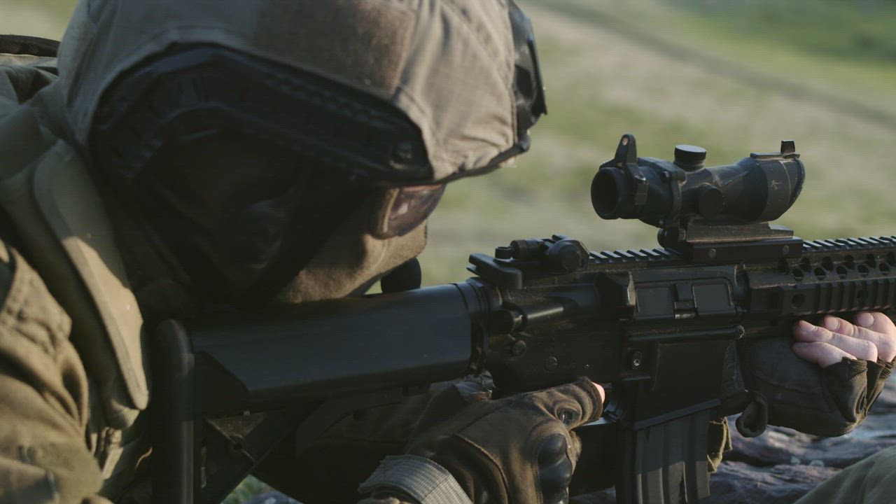 Soldier looking through the eye piece of a rifle - Free Stock Video