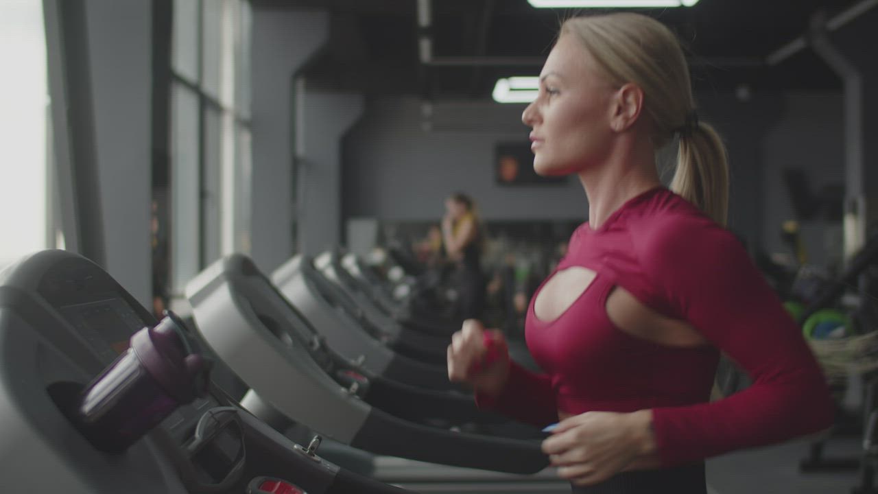 Slow motion of a woman in sportswear jogging on a treadmill - Free ...