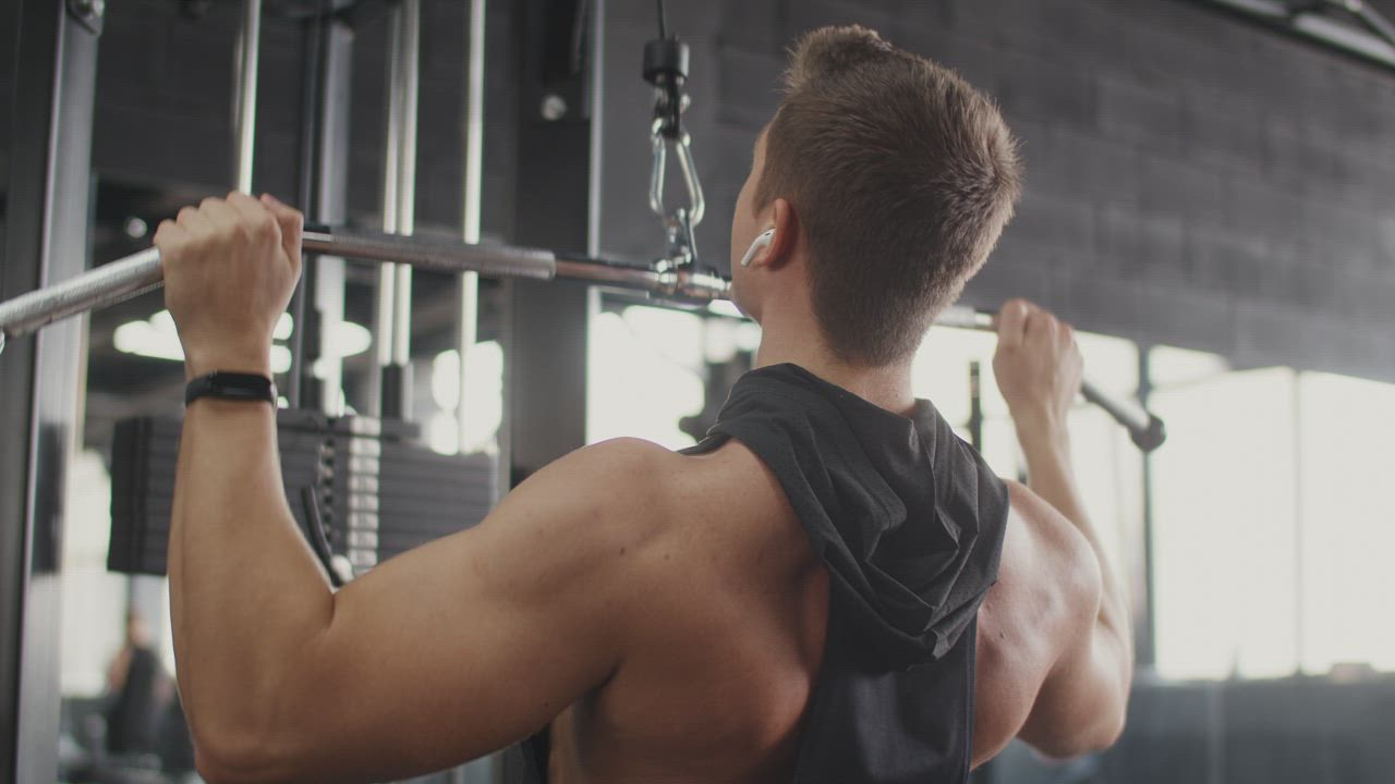 Athletic man working out on an weight machine at the gym - Free Stock Video