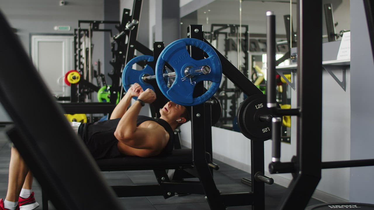Man completing a bench press at the gym - Free Stock Video