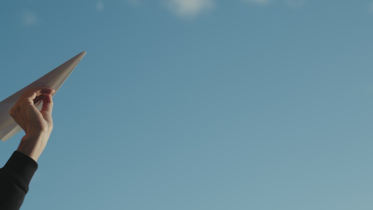 Hand flies a paper airplane with the blue sky in the background - Free ...