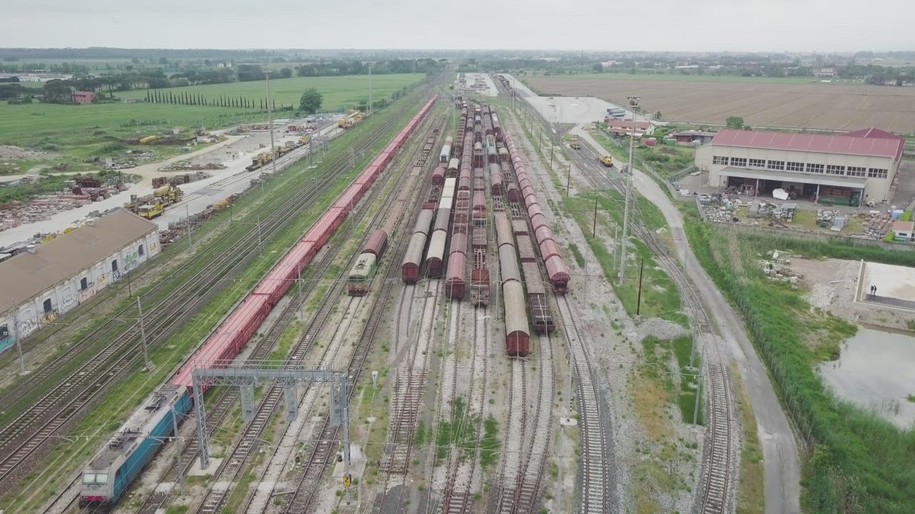 View of multiple freight trains parked near a warehouse - Free Stock Video