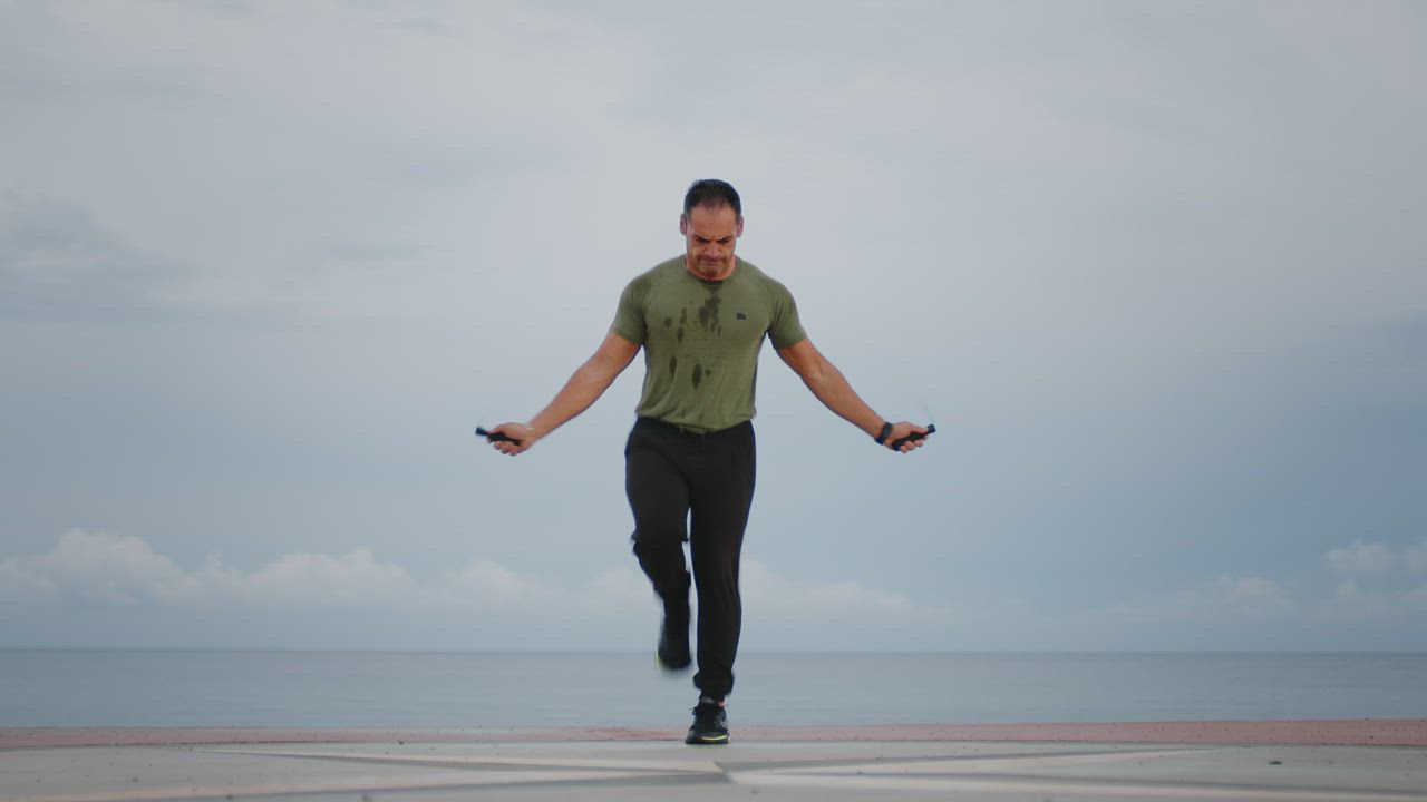 Man exercising with a jumping rope near the sea - Free Stock Video
