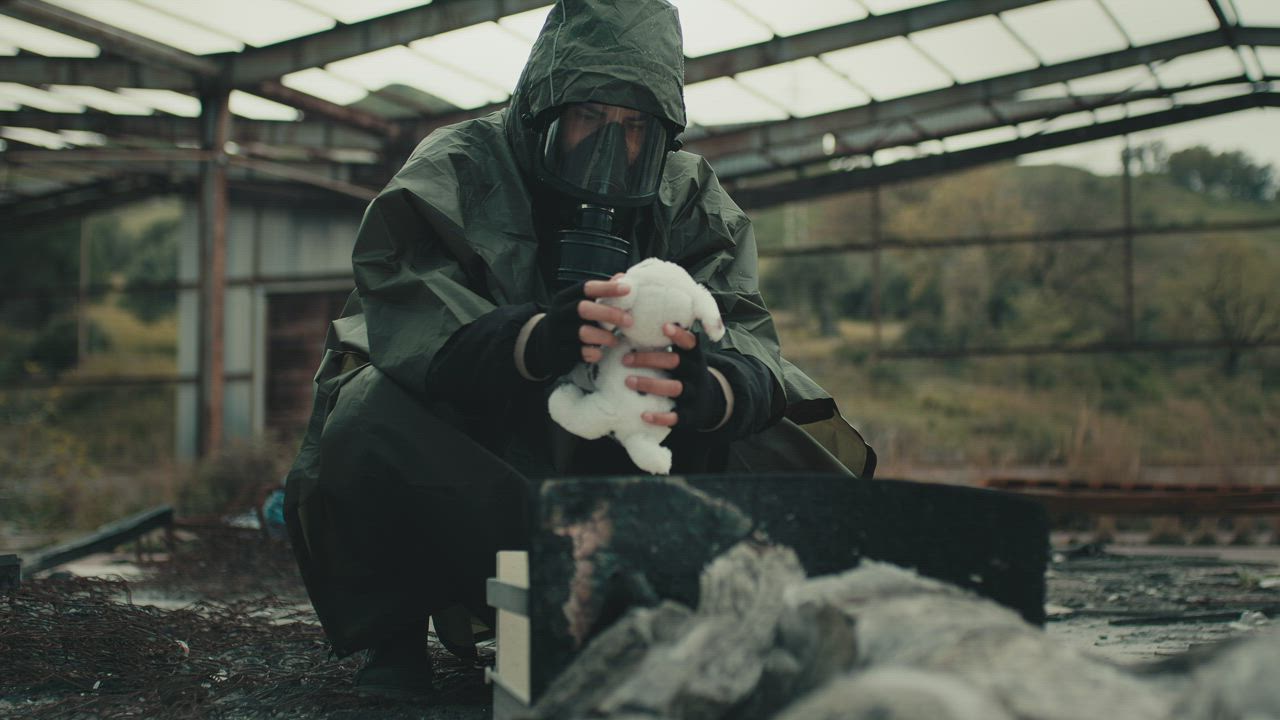 Man in gas mask finds a teddy bear in a destroyed warehouse - Free ...