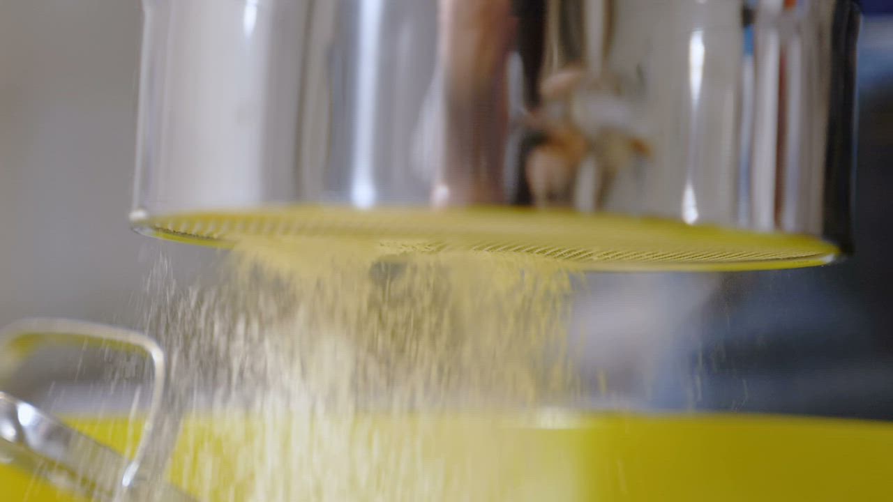 Slow motion sifting flour through a metal sieve - Free Stock Video