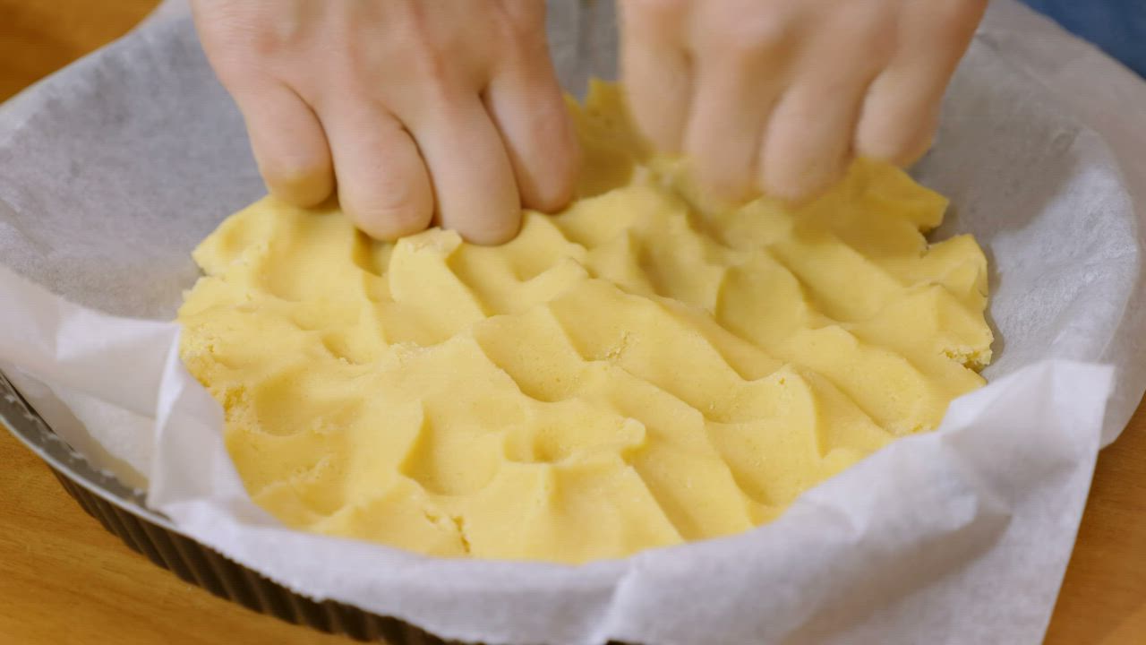 White hands pressing pastry base into a baking pan - Free Stock Video