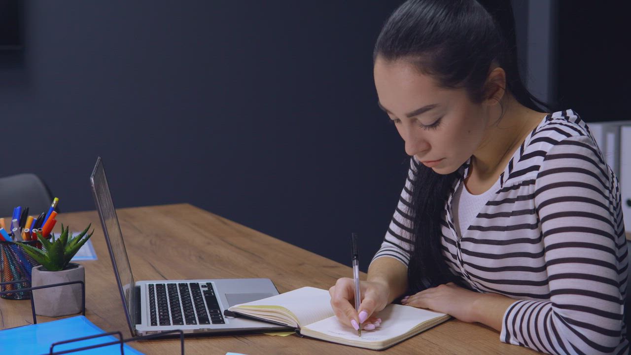 Young woman writes a list on her work schedule - Free Stock Video