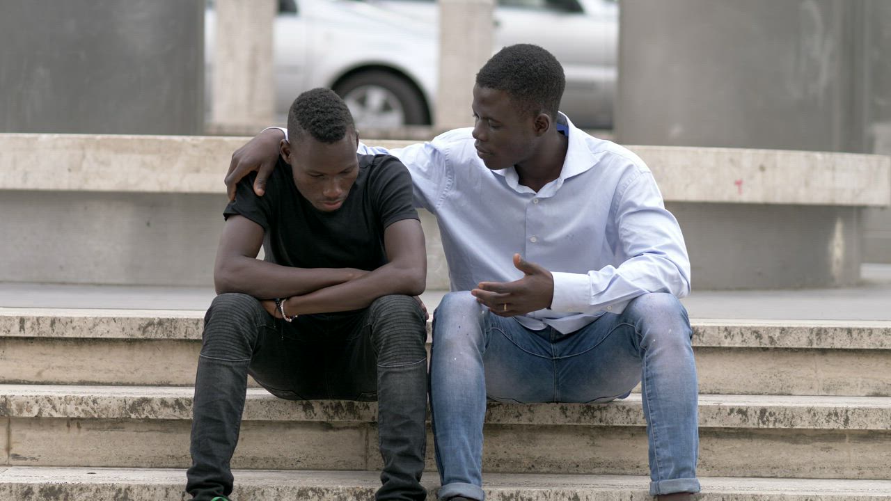 Black big brother comforts younger brother and they hug - Free Stock Video