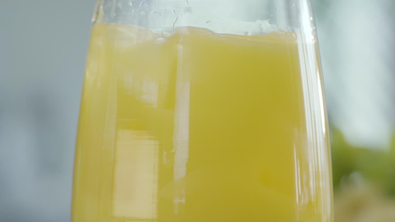 Glass with ice and juice spinning - Free Stock Video