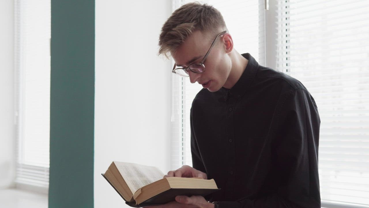 Young man reading a Bible aloud - Free Stock Video