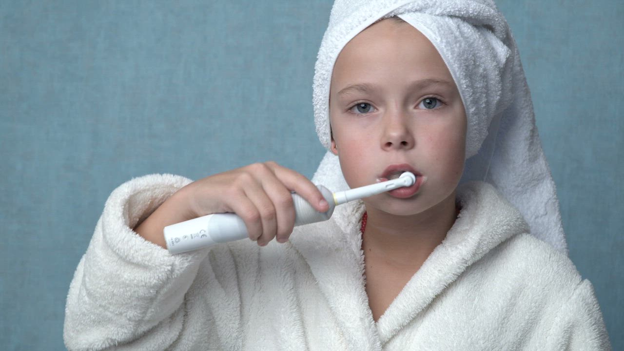 Young girl brushing her teeth with electric toothbrush - Free Stock Video