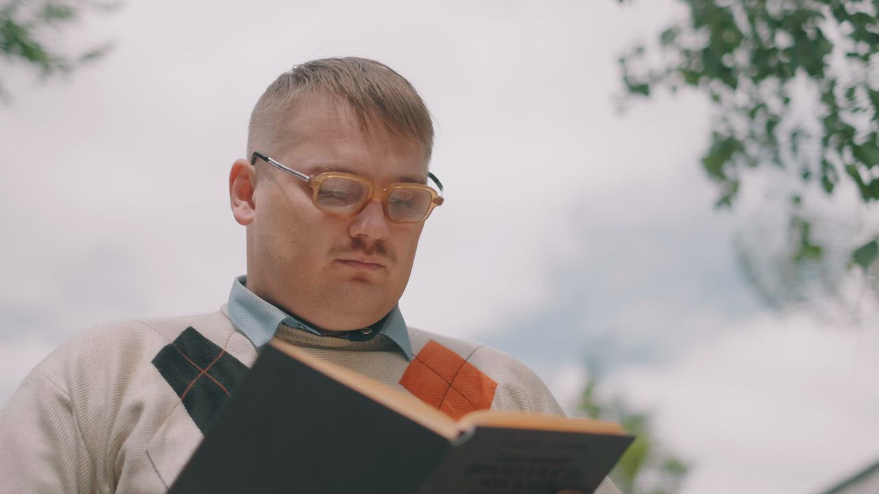 Guy reading outdoors - Free Stock Video