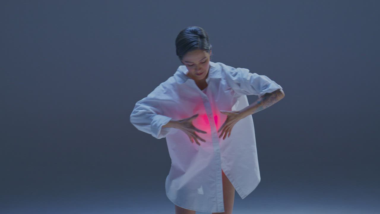 Girl with light on her chest doing a contemporary dance - Free Stock Video