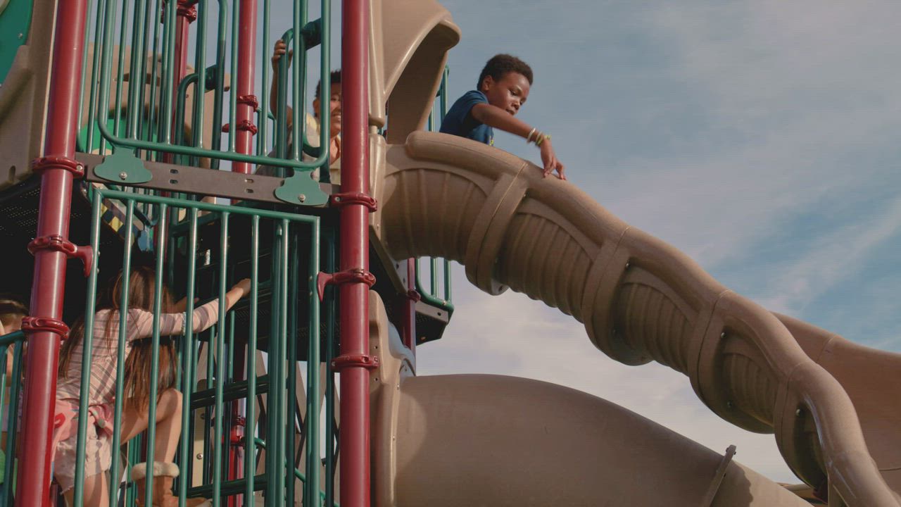 Children sliding down a slide - Free Stock Video