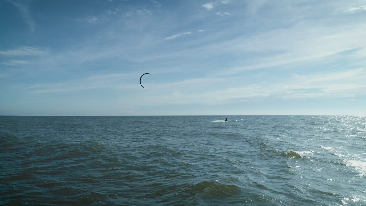 Distance shot of a kitesurfer followint the camera - Free Stock Video