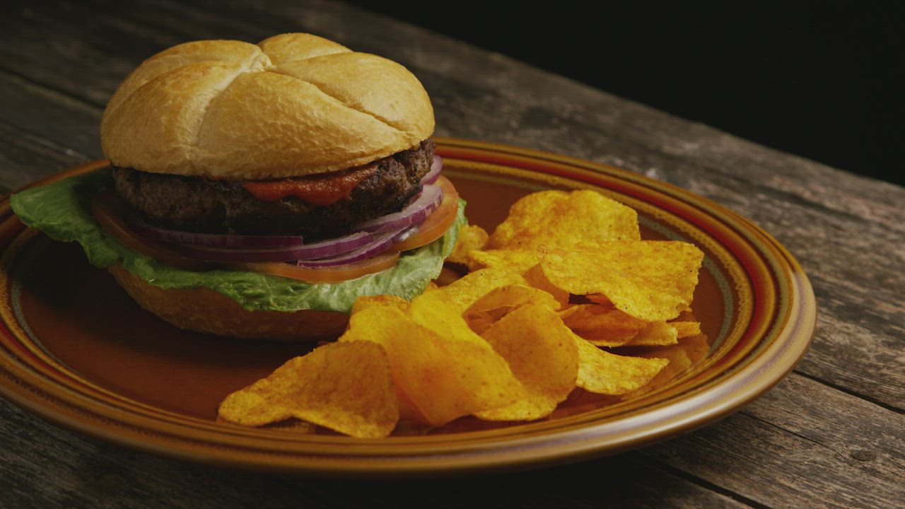 Plate of food with chips and cheeseburger - Free Stock Video