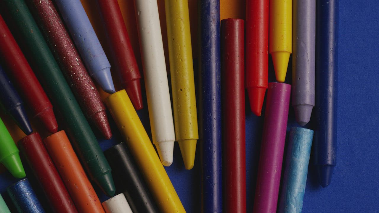 Crayons spread across colourful paper - Free Stock Video