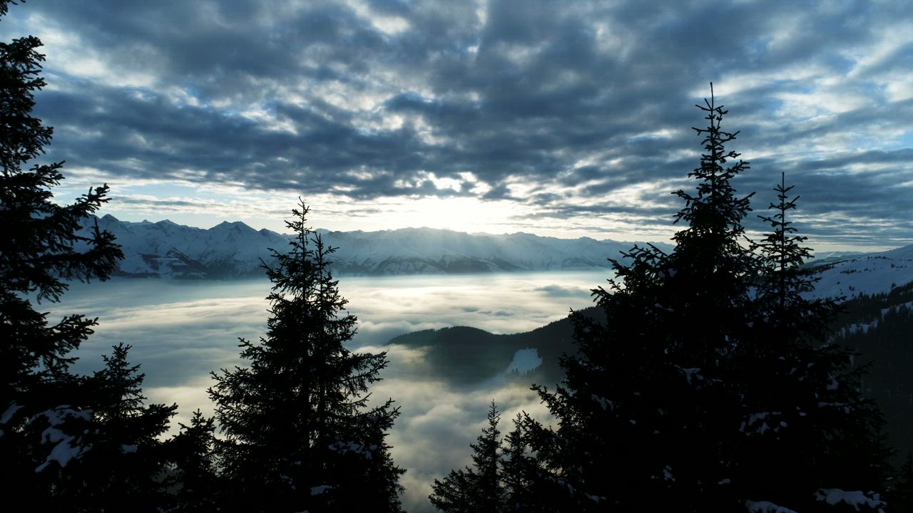 Aerial view of clouds in a valley beneath snowy mountains - Free Stock ...