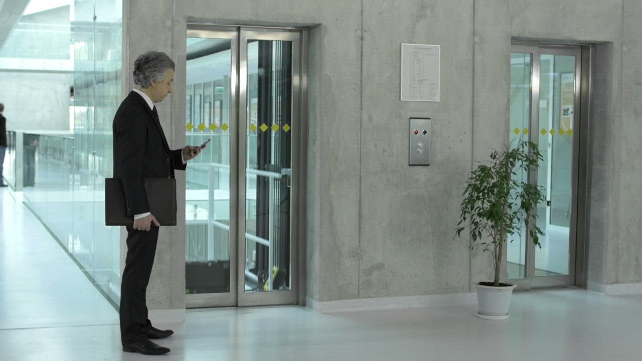 Colleagues greet each other in the office lobby - Free Stock Video