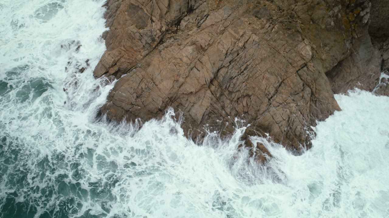 Aerial view of gigantic waves crashing onto rocks - Free Stock Video