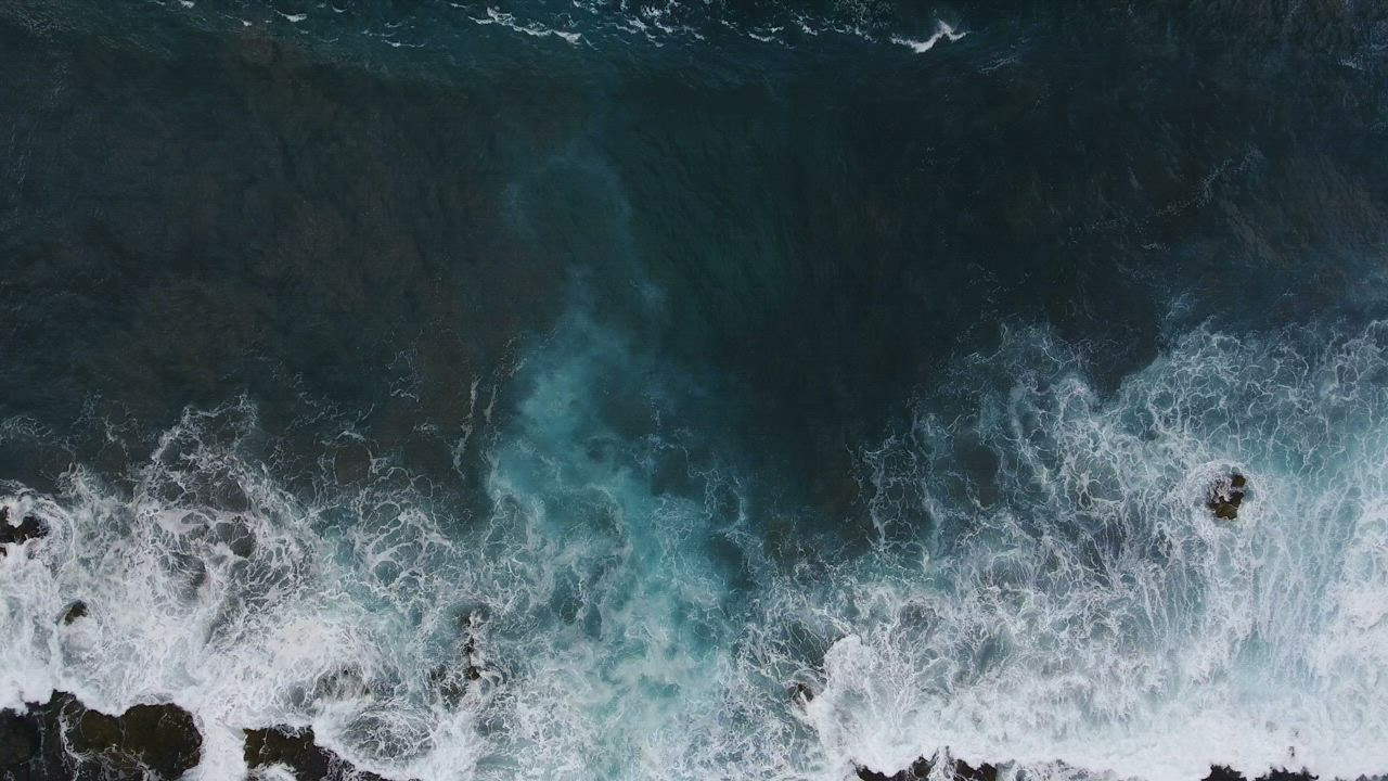 Aerial view of long running wave crashing onto shore - Free Stock Video