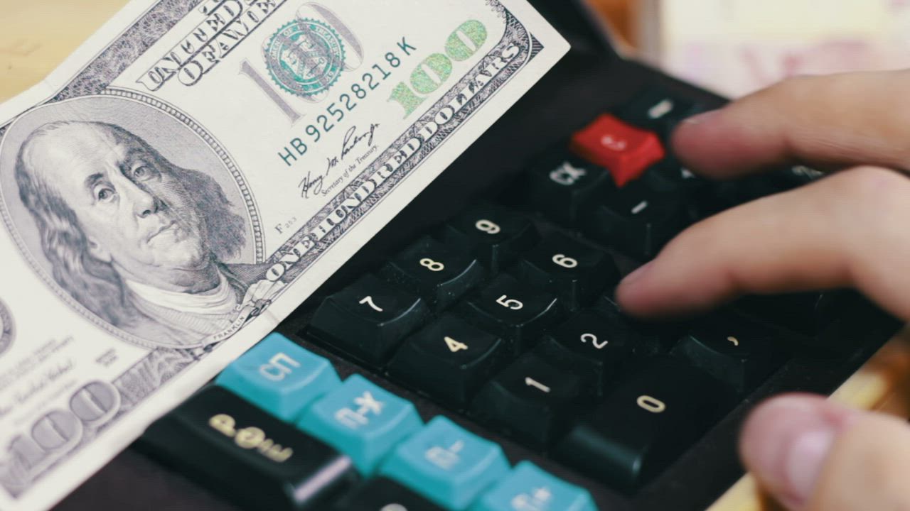 Man counting money on a old calculator - Free Stock Video
