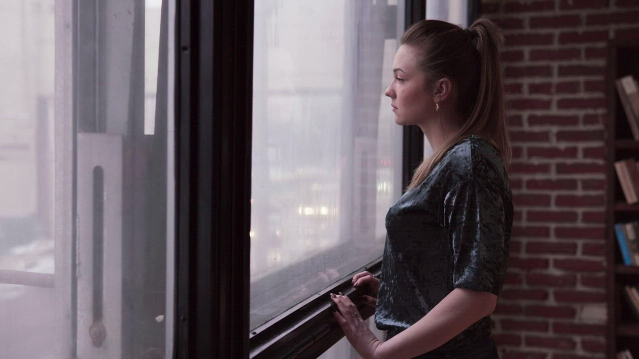 Young woman staring out the window in boredom - Free Stock Video