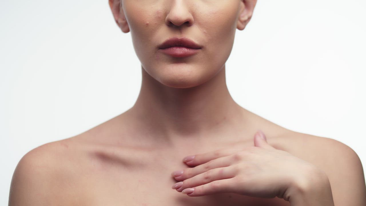 Model running her hand across her collarbone - Free Stock Video