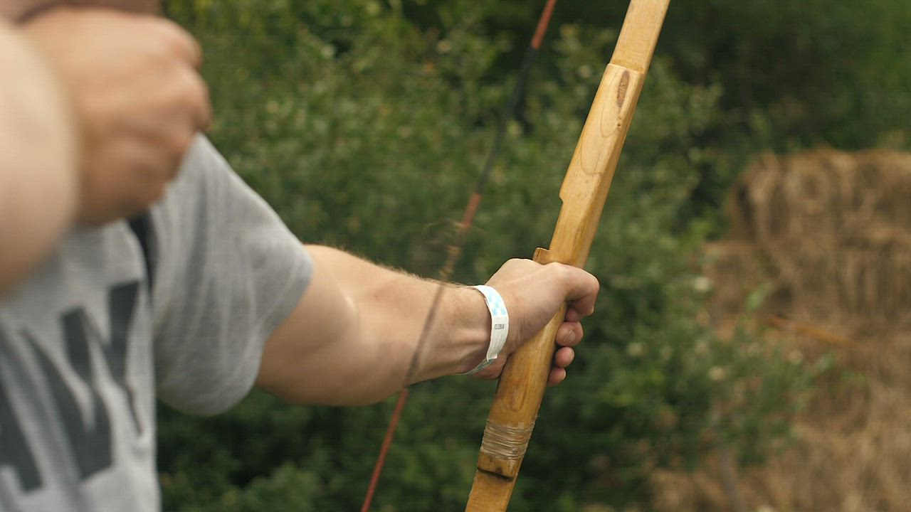 Close up of a person firing an arrow at a target - Free Stock Video