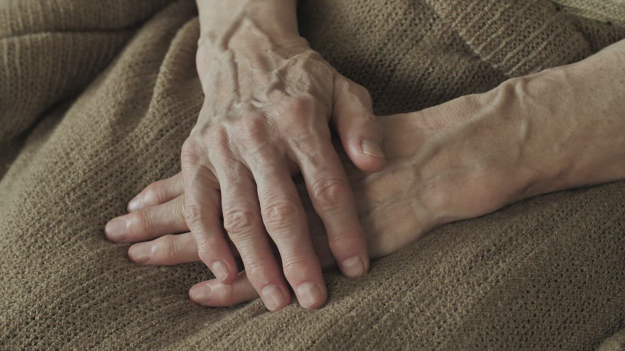 Elderly woman resting her hands in her lap - Free Stock Video