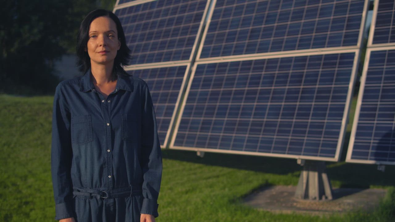 Woman standing in front of a solar panel - Free Stock Video